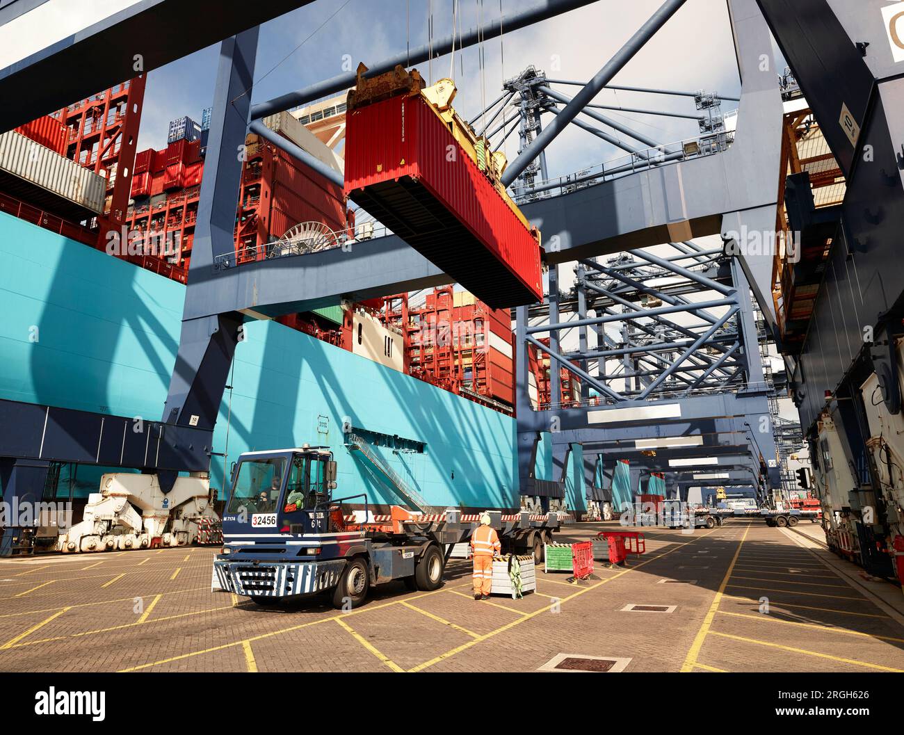 Crane lowering cargo container onto truck at Port of Felixstowe ...