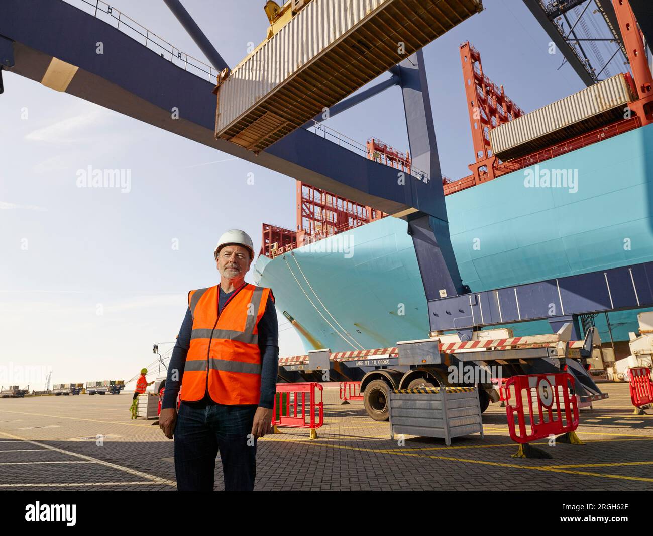 Dock worker by cargo container and truck at Port of Felixstowe, England ...
