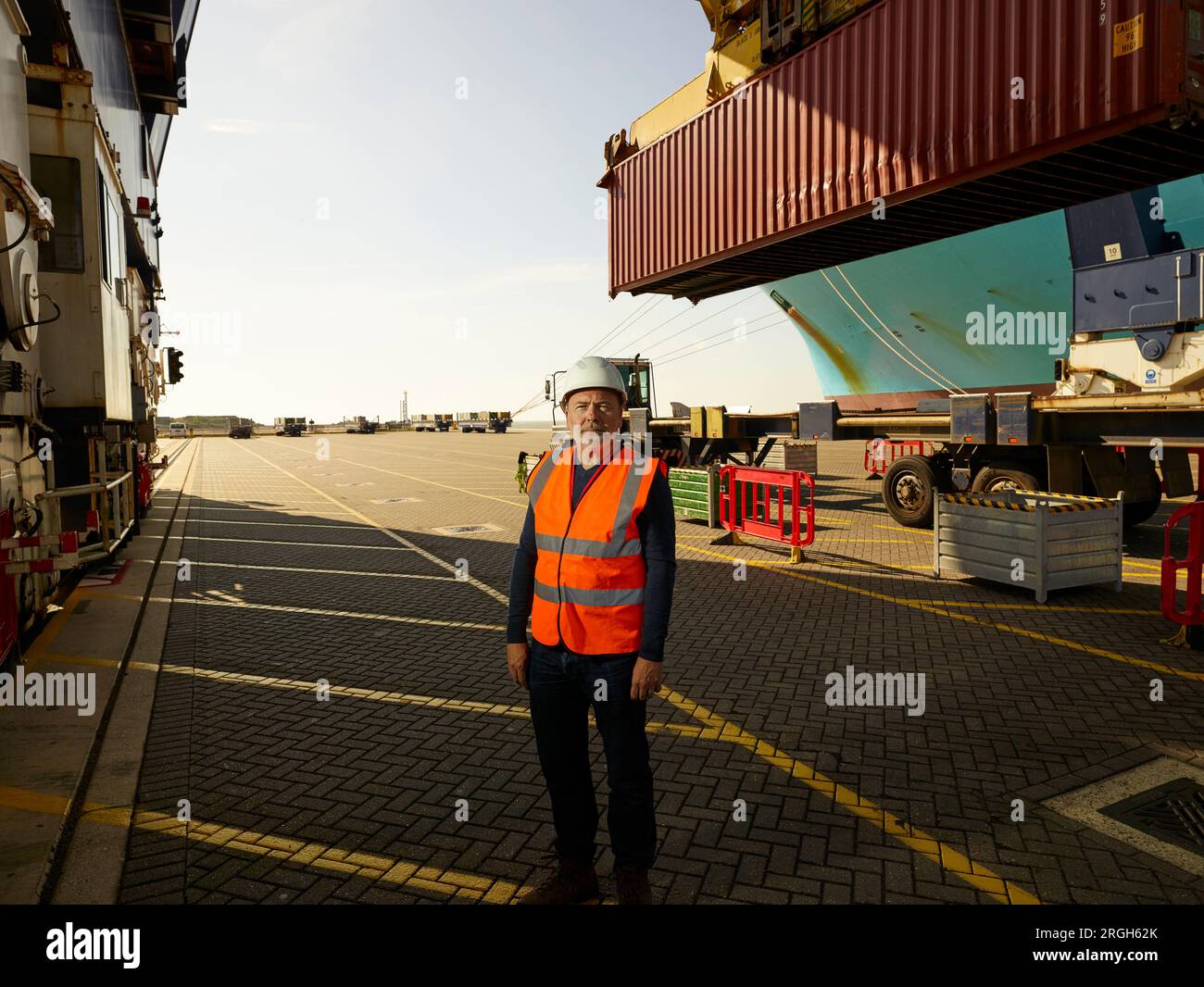 Dock worker by cargo container and truck at Port of Felixstowe, England ...