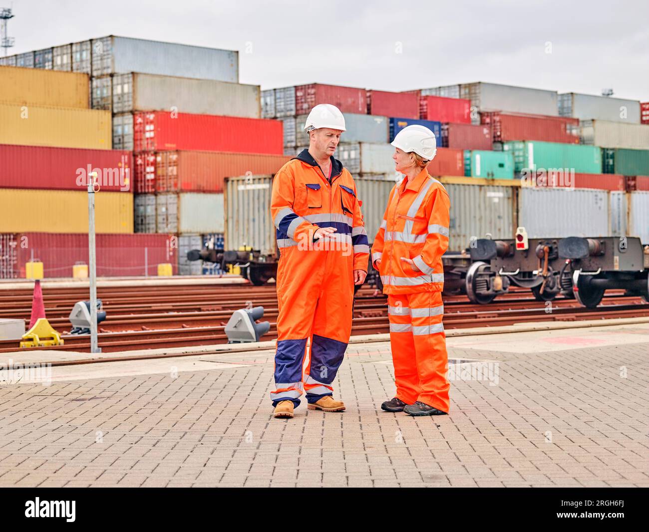 Dock workers talking by railroad tracks Stock Photo - Alamy