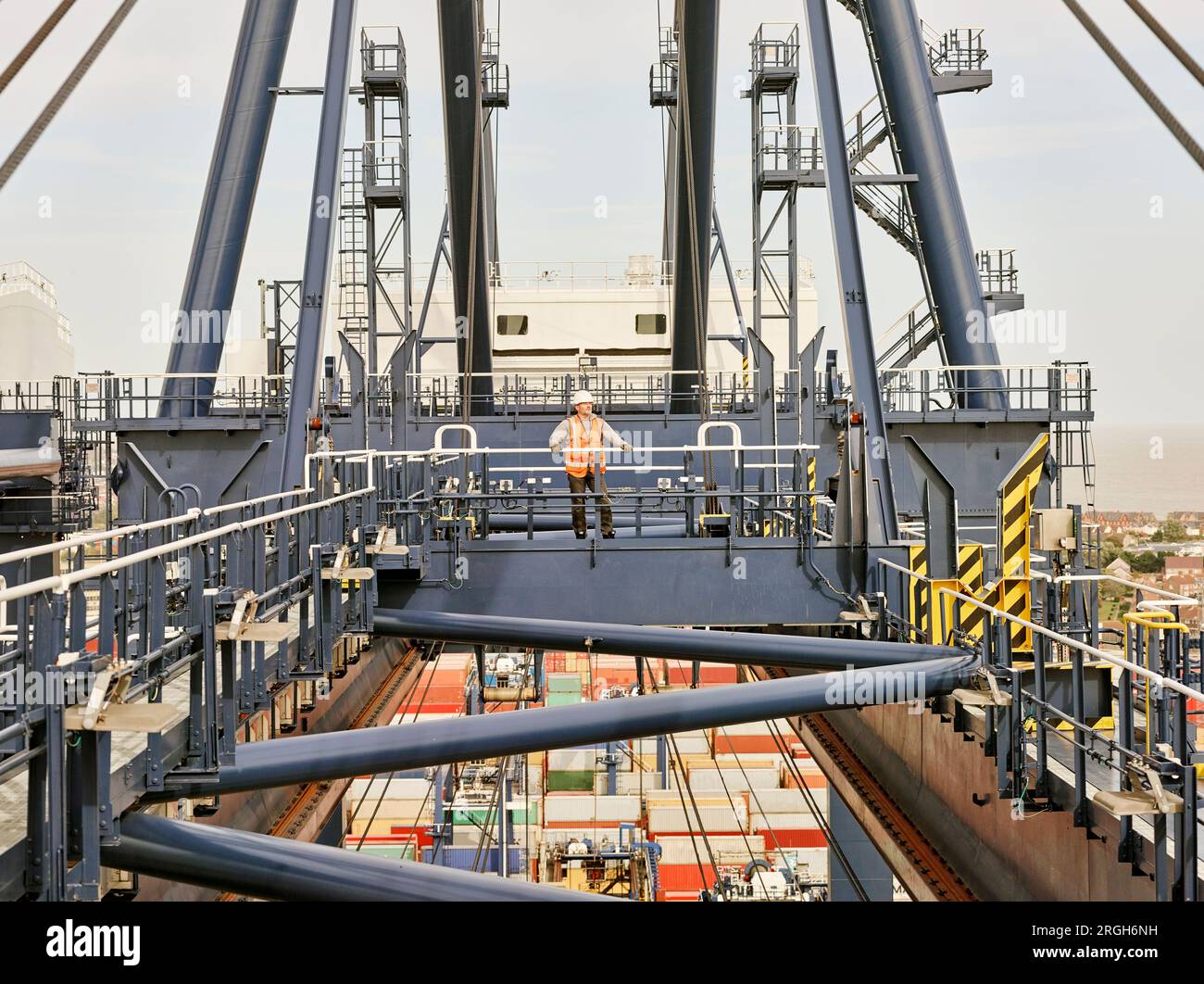 Dock worker looking at view from crane railing Stock Photo - Alamy