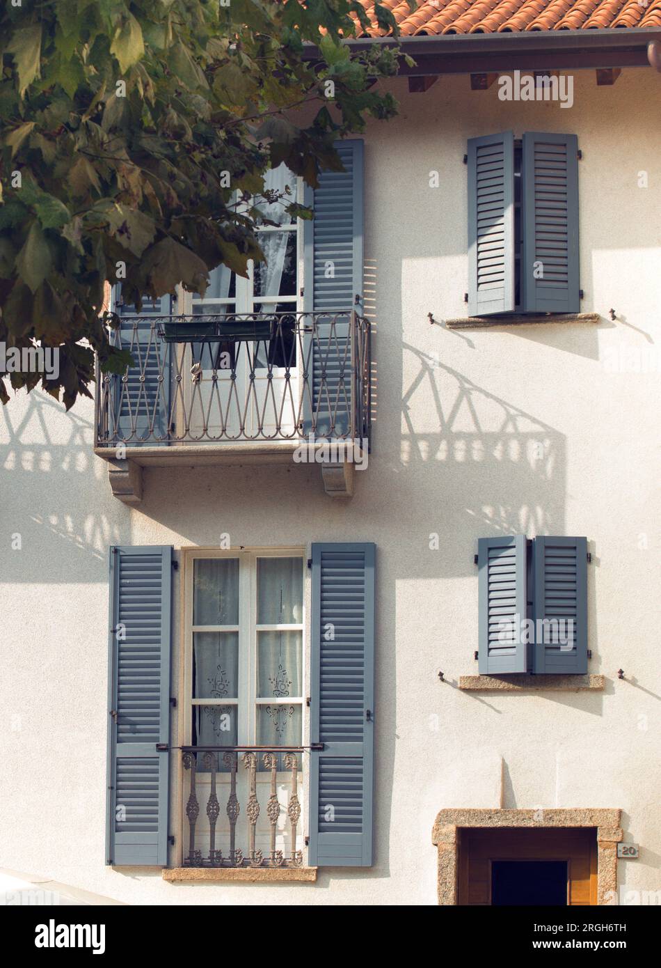 House with blue shutters Stock Photo - Alamy