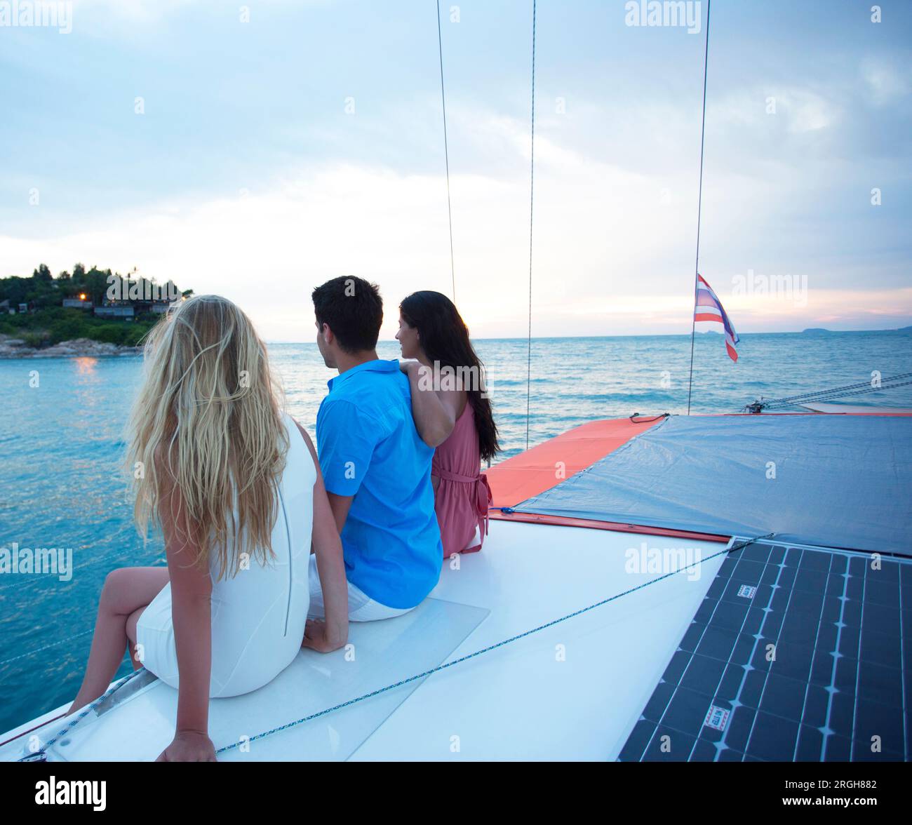 Three friends enjoying a sunset sailboat ride Stock Photo - Alamy