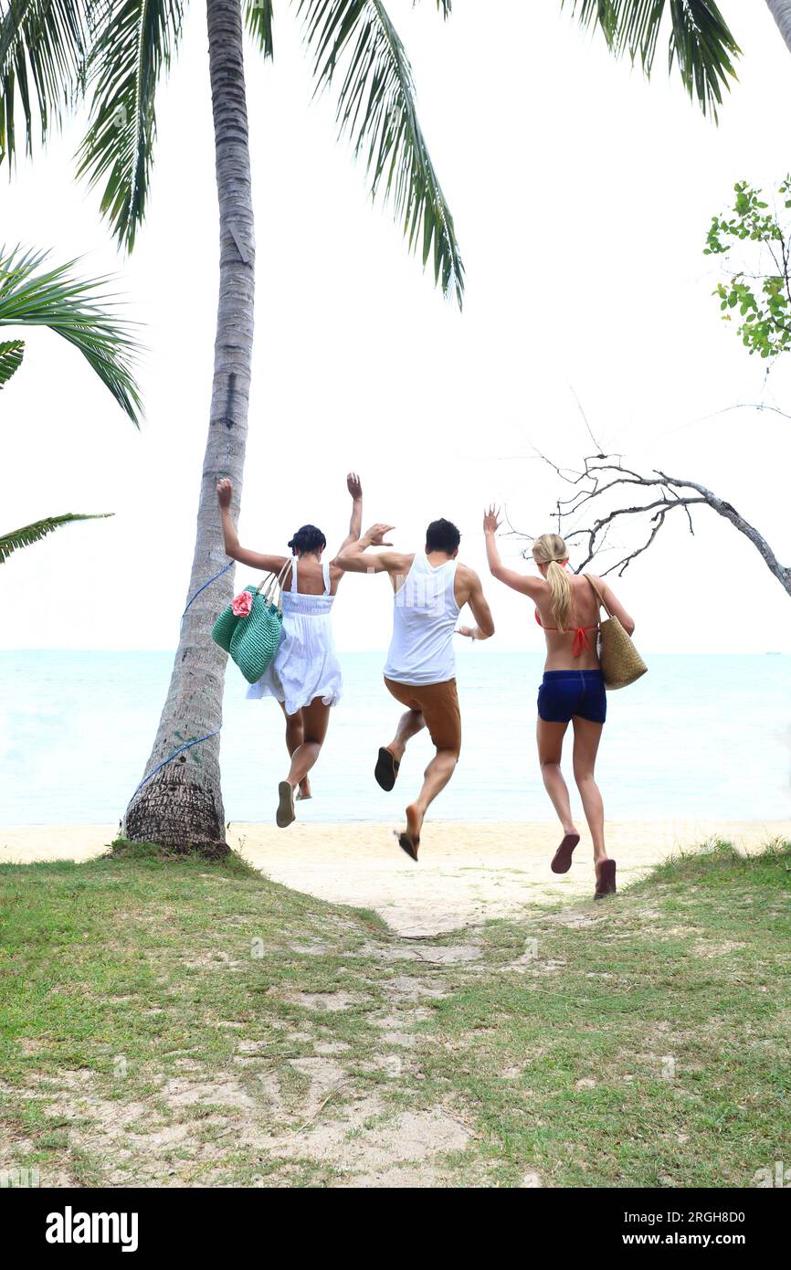 Young people jumping by beach Stock Photo - Alamy