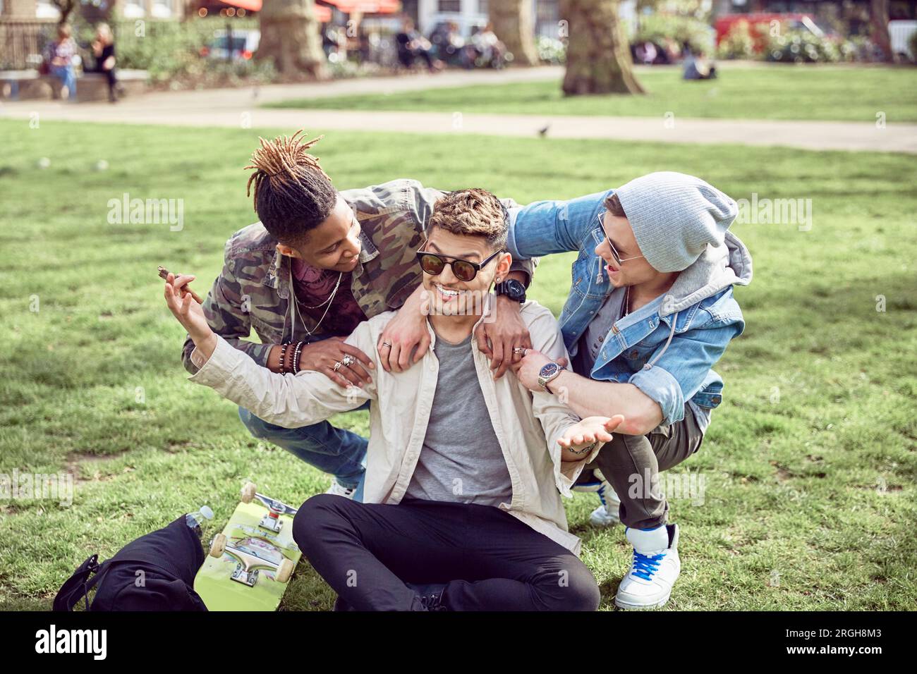 Teenage boys play fighting in park Stock Photo - Alamy