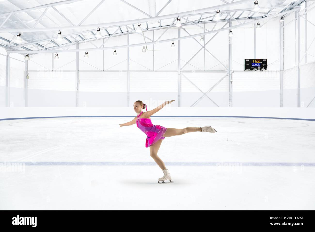 Young woman in pink dress figure skating at ice rink Stock Photo - Alamy