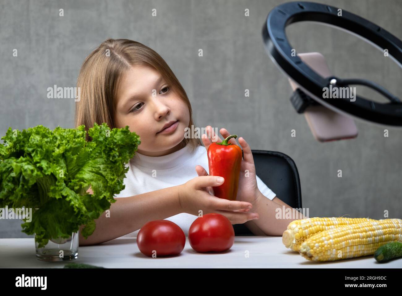 A beautiful blond teenage girl broadcasts live about healthy eating ...