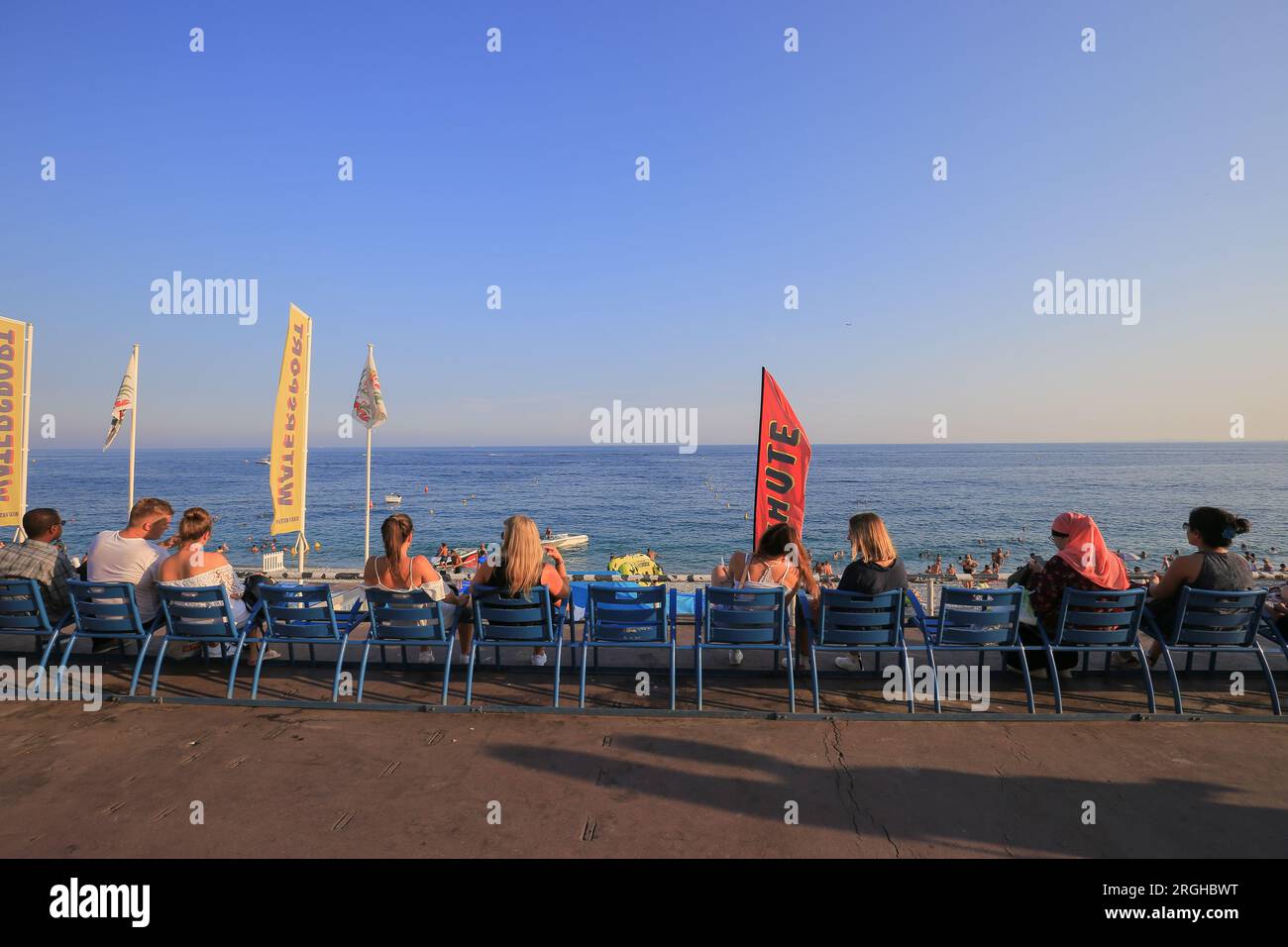 People sit on blue chairs on the French Riviera promenade in Nice Stock ...