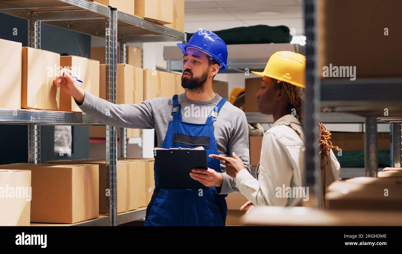 Multiethnic group of people working in storage room with cardboard ...