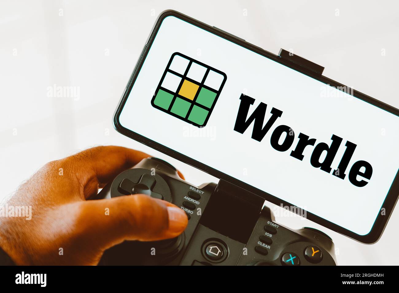 In this photo illustration, a person plays on a joystick and the Wordle ...