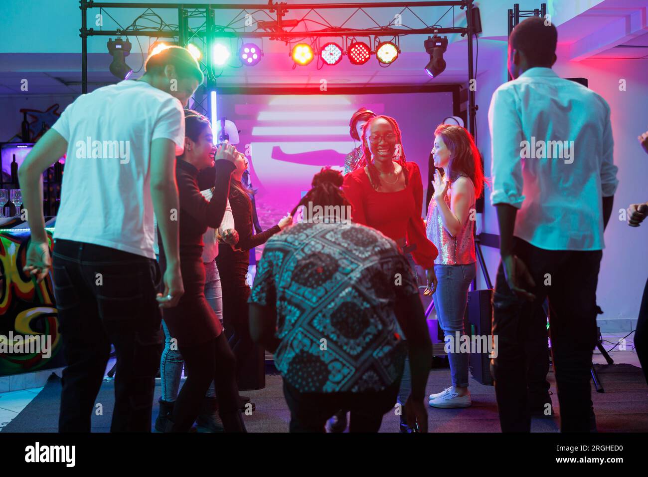 People dancing in nightclub full of young diverse clubbers having fun ...