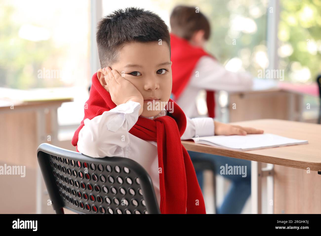 Little schoolboy sitting in classroom Stock Photo - Alamy