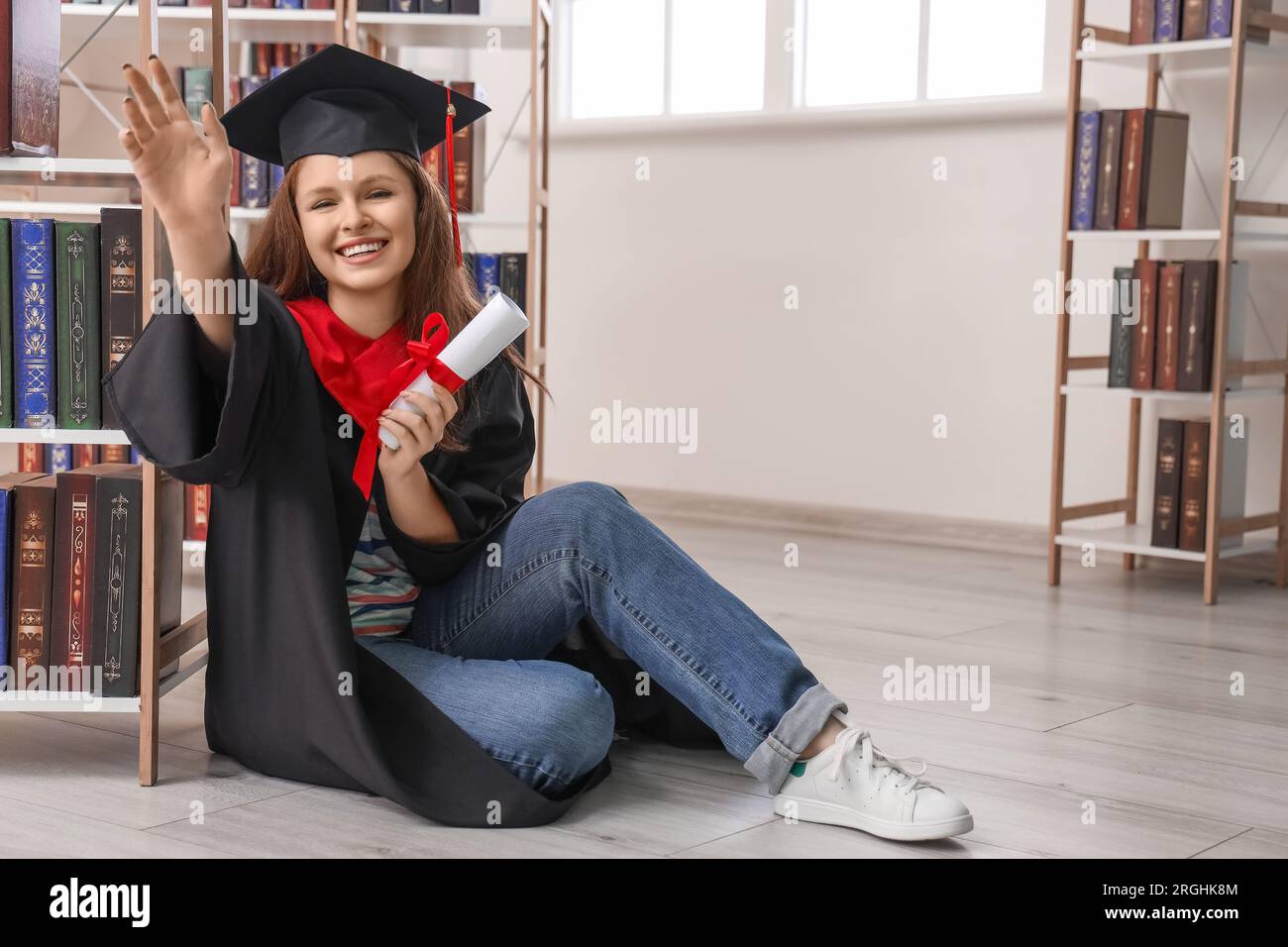 Female graduate student with diploma in library Stock Photo - Alamy