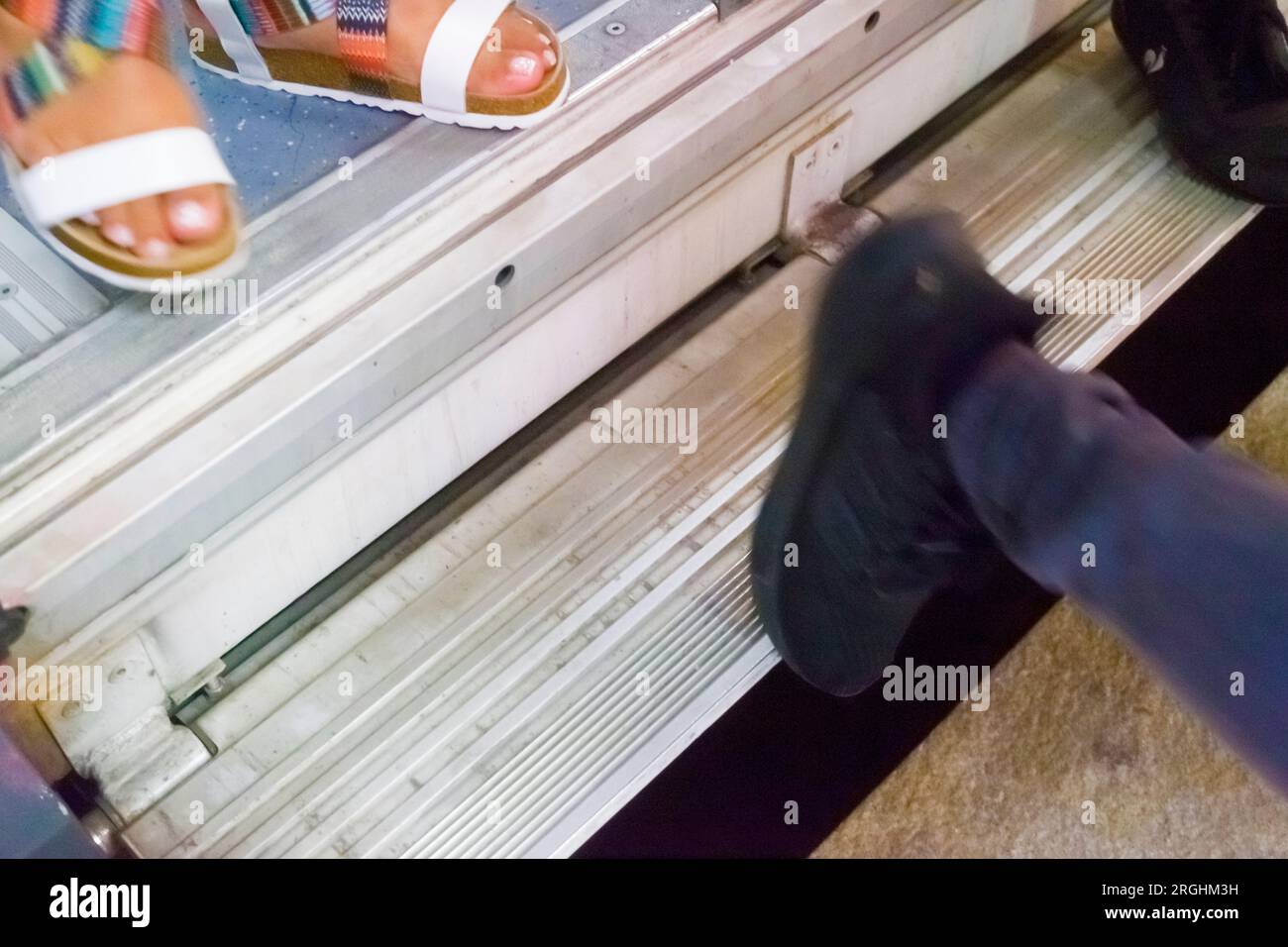 Close up view of the feet of two people on the steps of the commuter ...