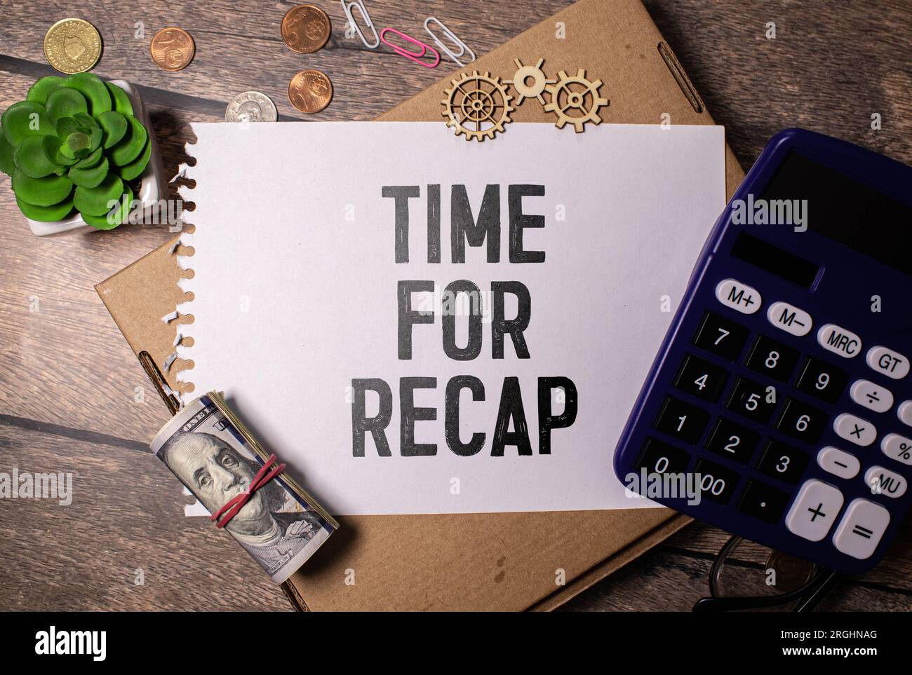 The text TIME FOR RECAP appearing on yellow paper behind torn color ...