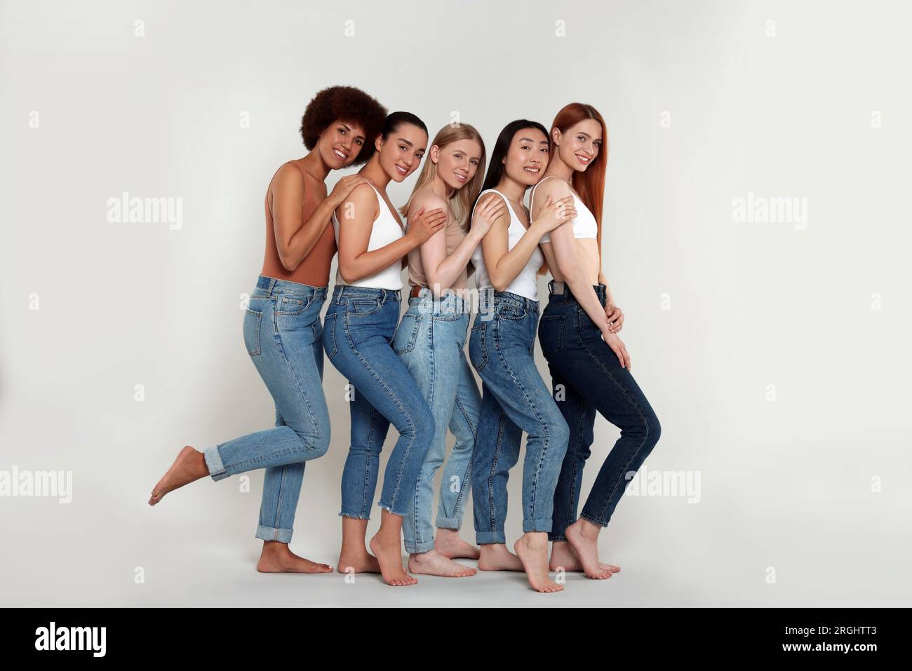 Group of beautiful young women on light grey background Stock Photo - Alamy