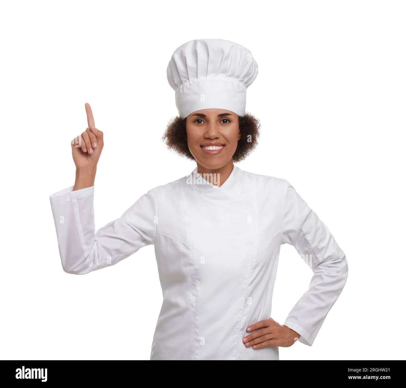 Happy female chef in uniform pointing at something on white background ...