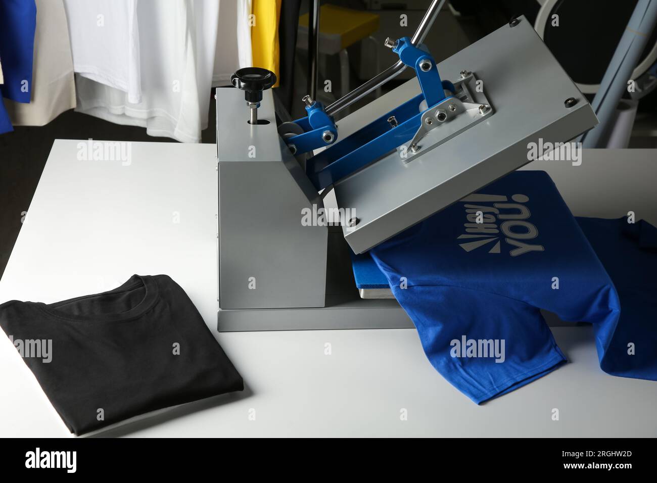 Printing logo. Heat press with blue t-shirt on white table Stock Photo ...