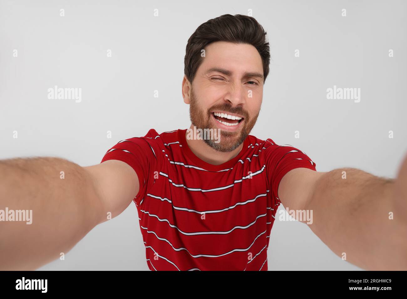 Smiling man taking selfie on white background Stock Photo - Alamy