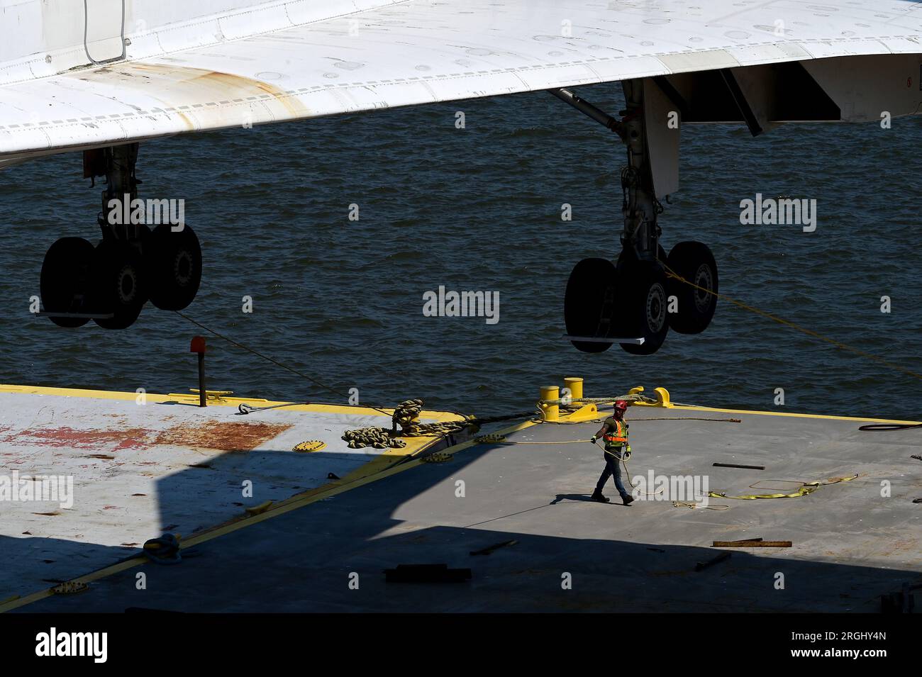 New York, USA. 09th Aug, 2023. A worker holds a guide rope under the ...