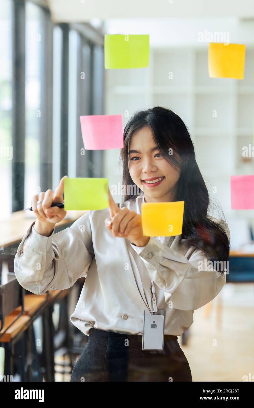 Through glass view of businesswoman analyzing process schedule ...