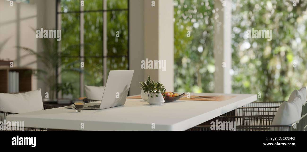 A laptop computer on a dining table in a modern dining room with a ...