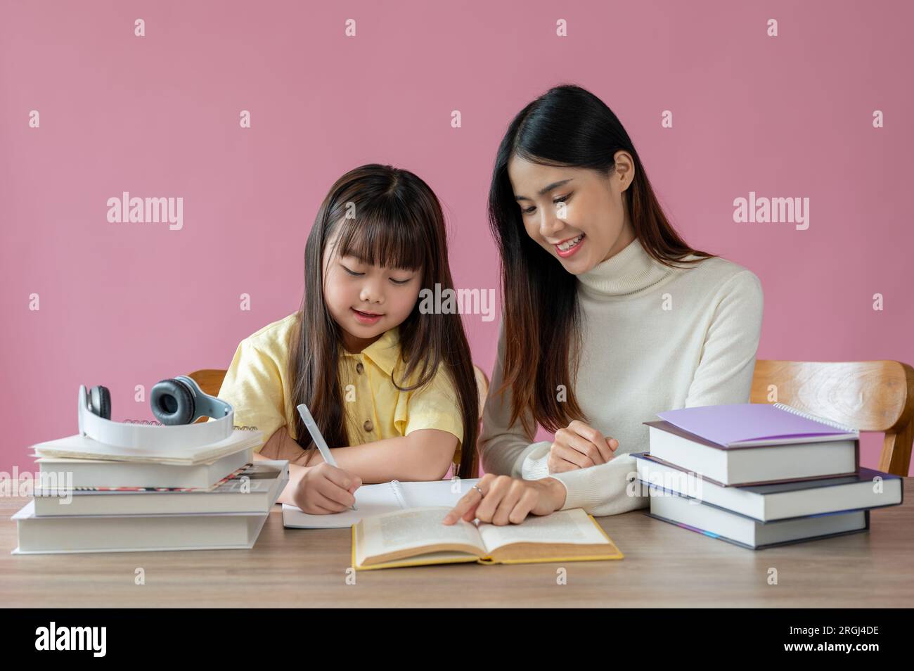 A caring and kind Asian sister or private teacher is teaching and ...