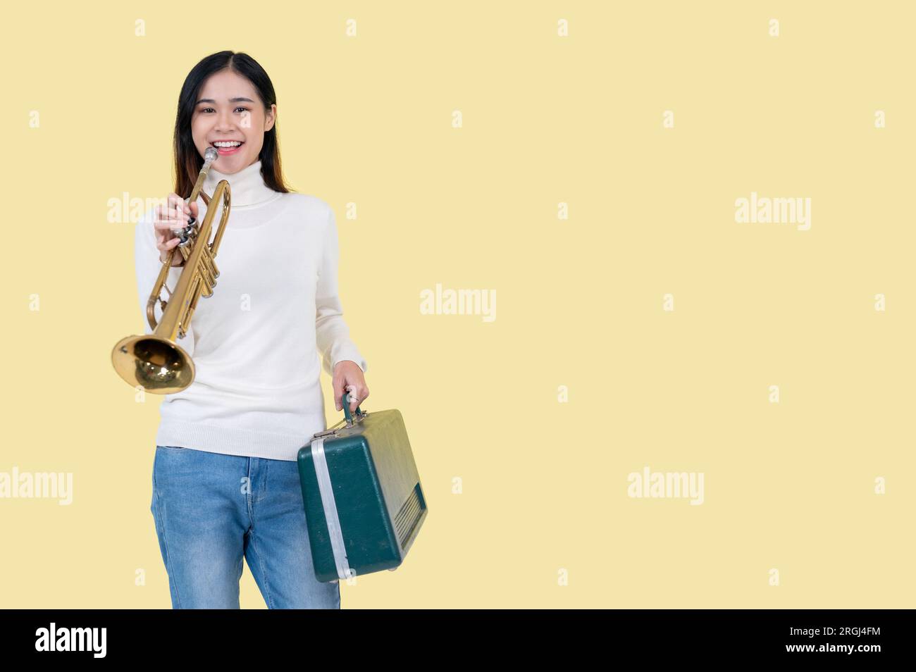 A beautiful and talented Asian woman is holding the trumpet while ...