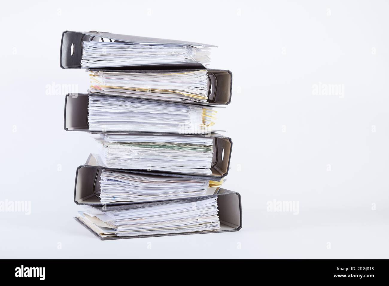 stack of black file folders full of documents against white background ...