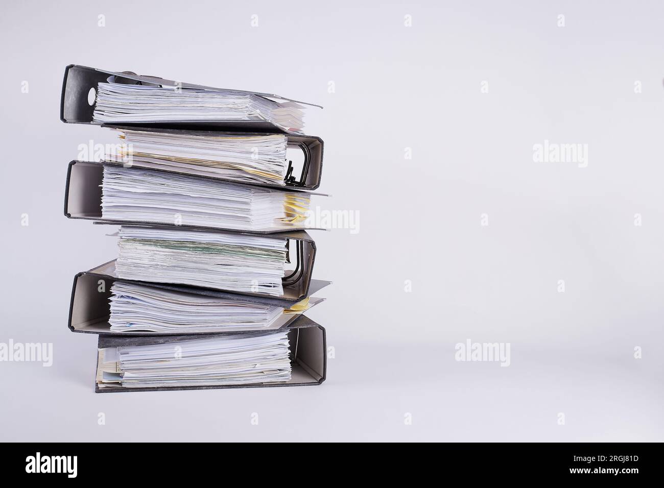 stack of black file folders full of documents against white background ...