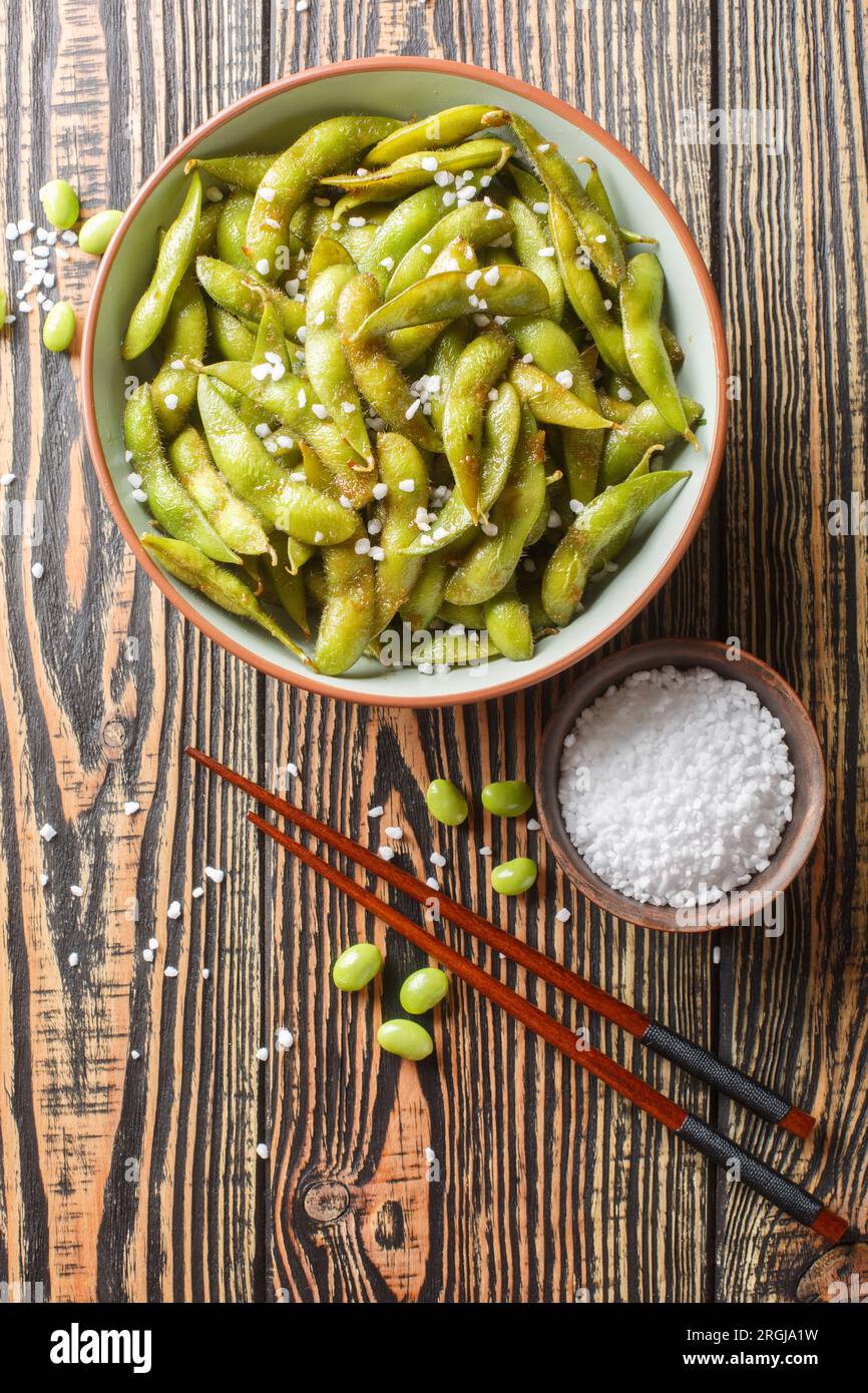 Roasted edamame beans seasoned with coarse sea salt close-up on a plate ...