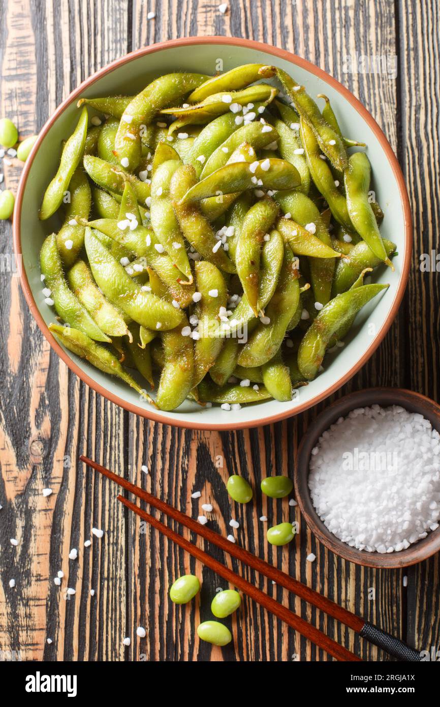 Asian style fried edamame bean pods seasoned with coarse sea salt close ...