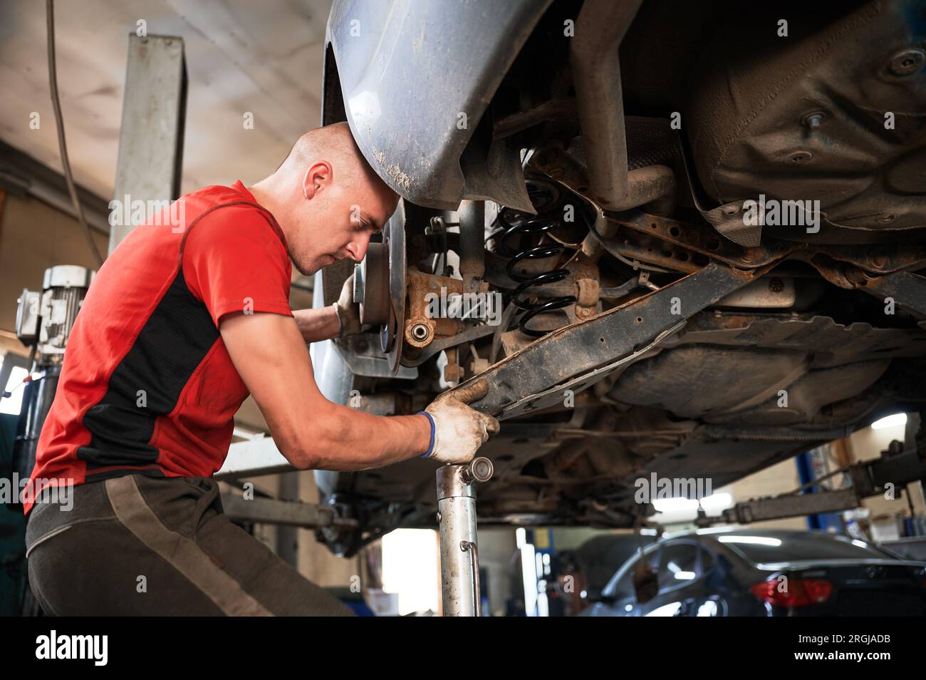 Professional worker, repairman changing car wheel, fixing problem. Hardworking, strong man ...