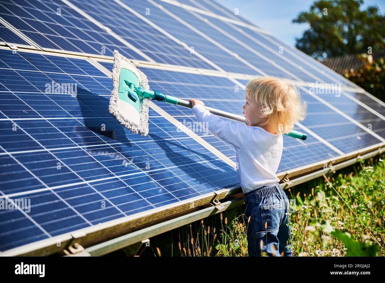 Little kid learning how to clean solar panel. Young boy learning how to ...