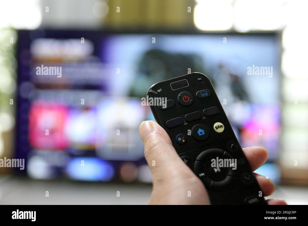 Cord Cutters Watching tv and using remote control Stock Photo - Alamy