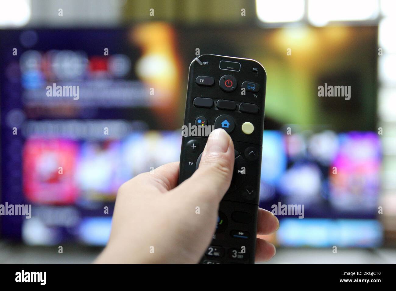 Cord Cutters Watching tv and using remote control Stock Photo - Alamy