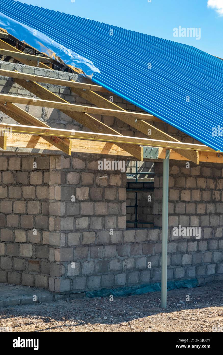 corrugated iron sheets on a roof half done, work in progress, wall not ...