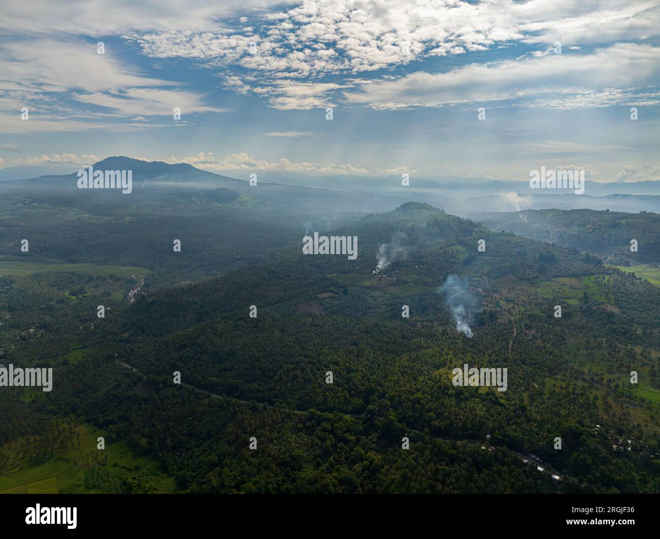 Mountain slopes with rainforest and a mountain valley with farmland ...