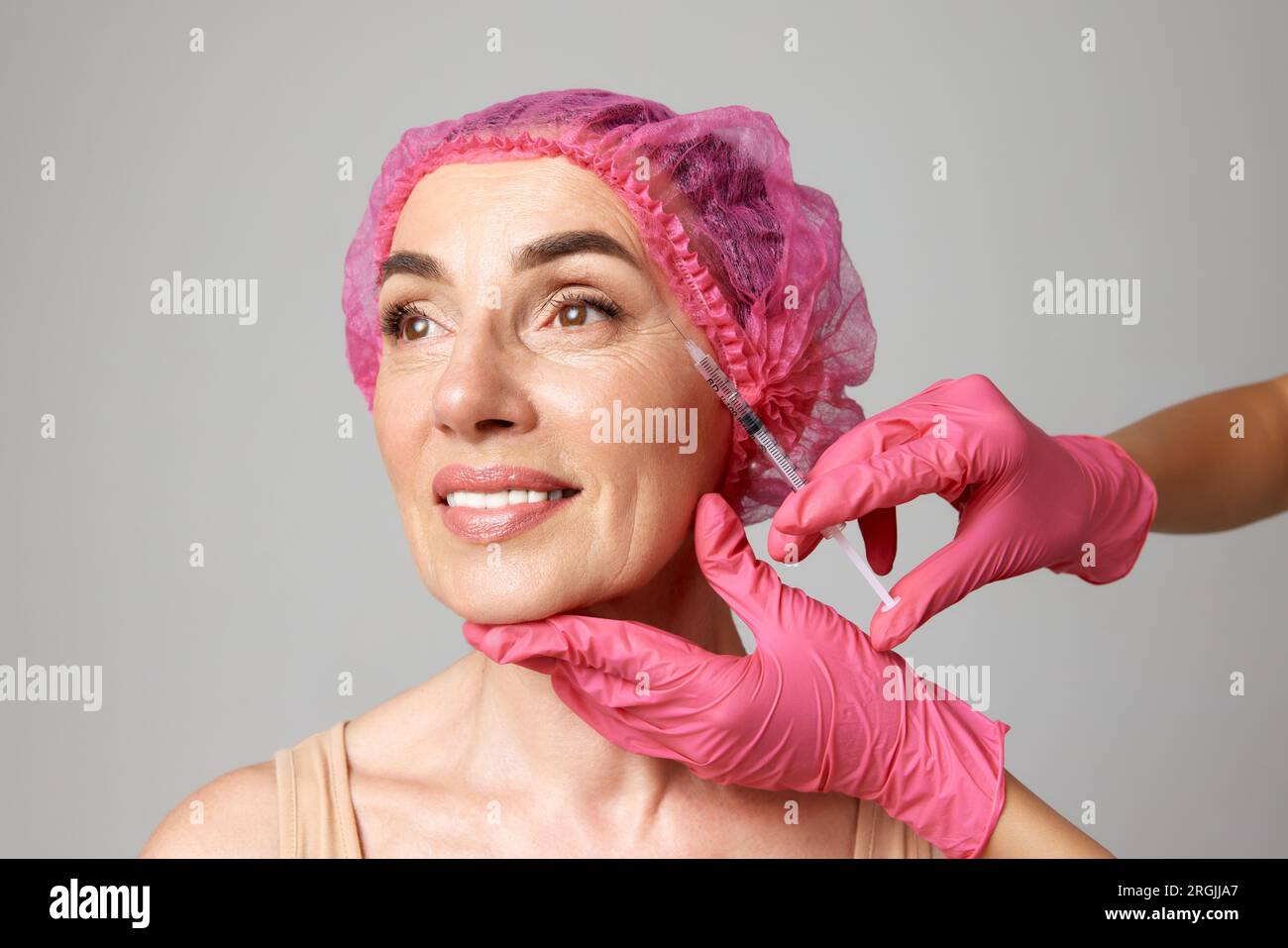 Portrait of middle-aged woman in pink caps for cosmetic treatments ...