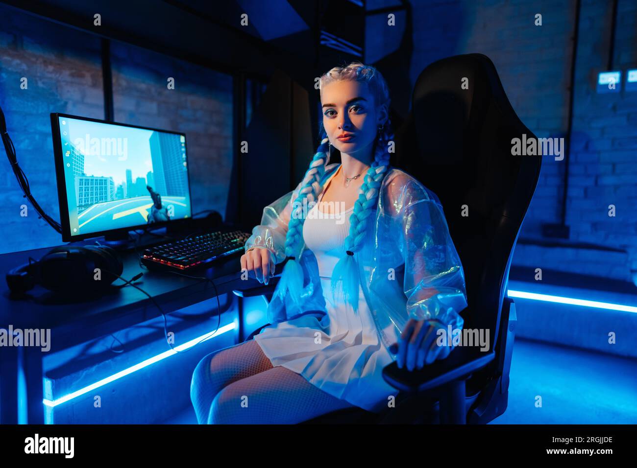 Young female blogger, gamer plays games on computer. Neon computer club ...