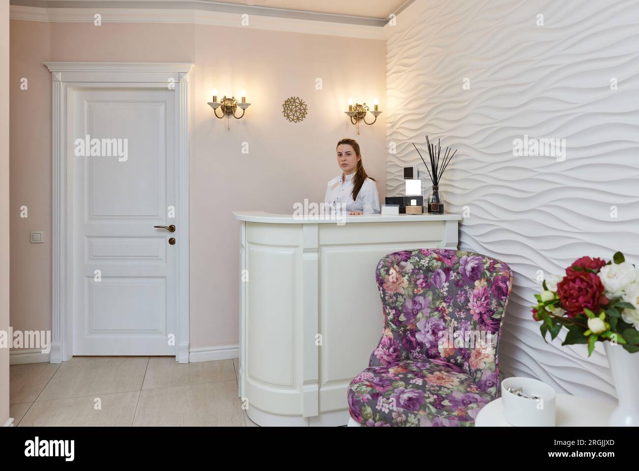 administrator sitting at a front desk and greeting customers Stock ...