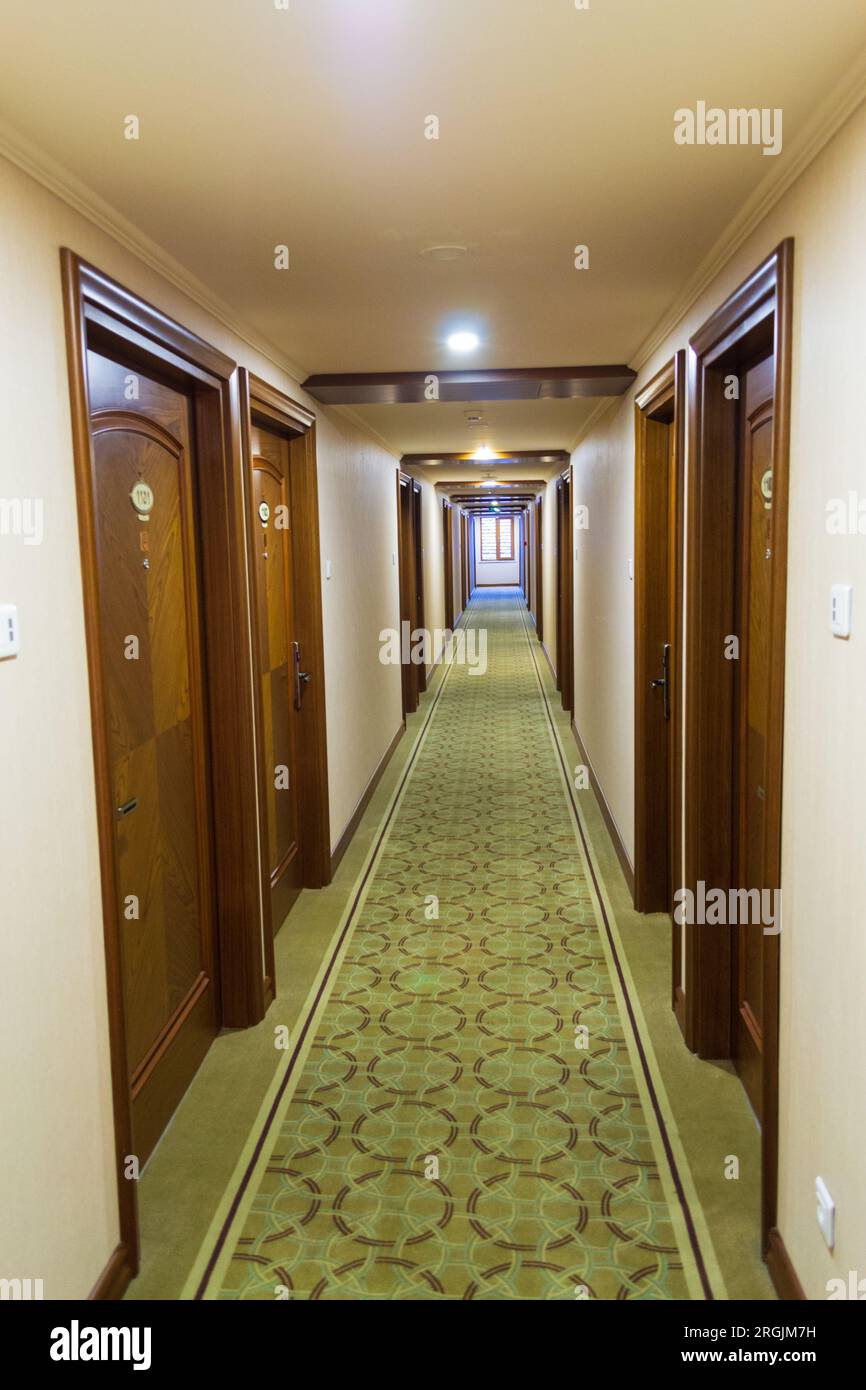 Long corridor with rooms doors and carpet of a hotel and light in the ...
