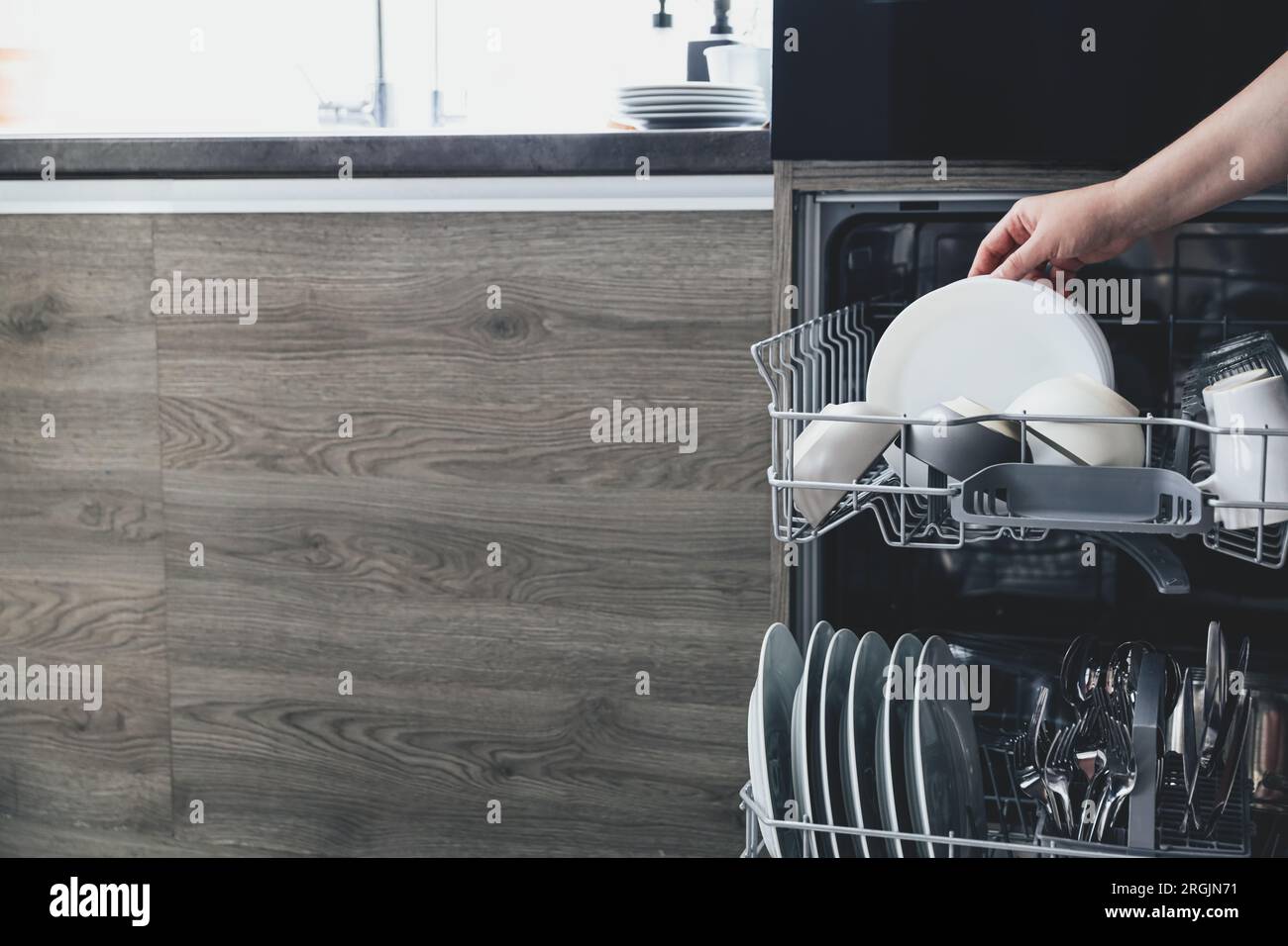 Close-up view of female woman hand unloading dishes, empty out or ...