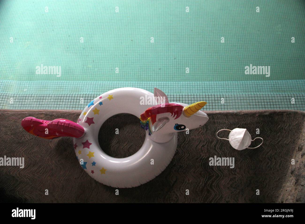 Pool to play on vacation next to flip-flops and an inflatable unicorn ...