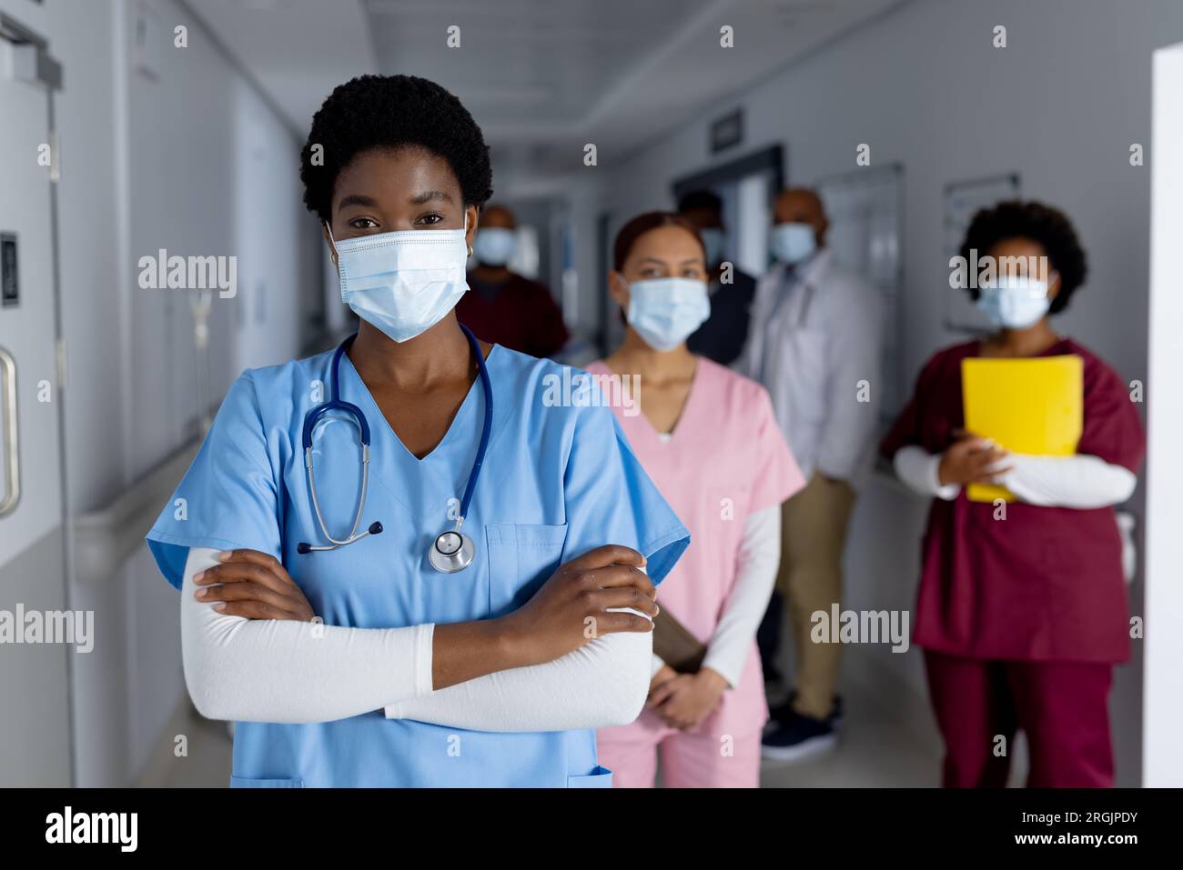 Portrait of diverse female doctors wearing face masks in corridor at ...