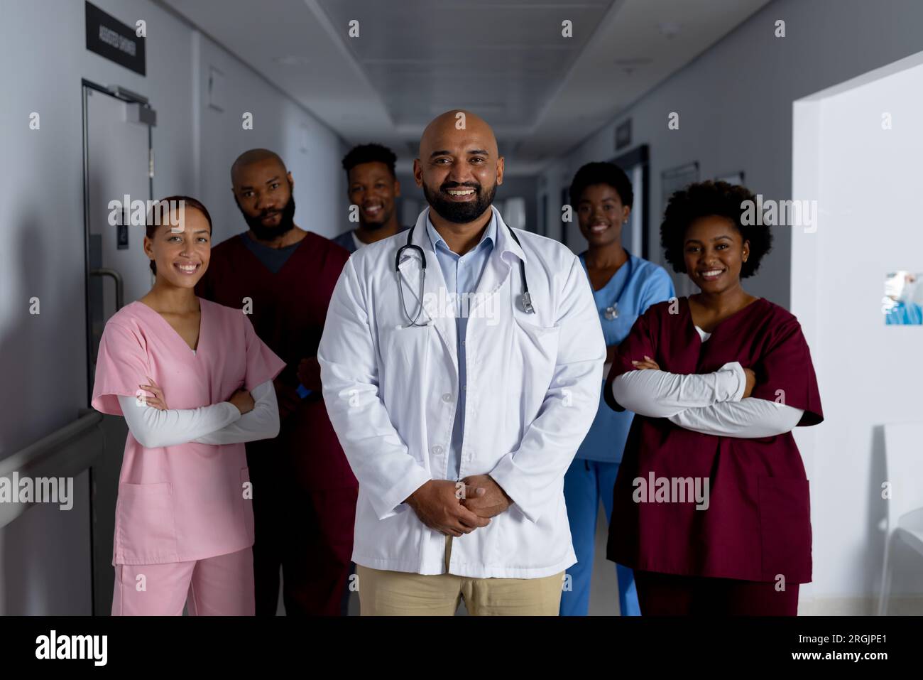 Portrait of happy diverse doctors standing in corridor at hospital ...
