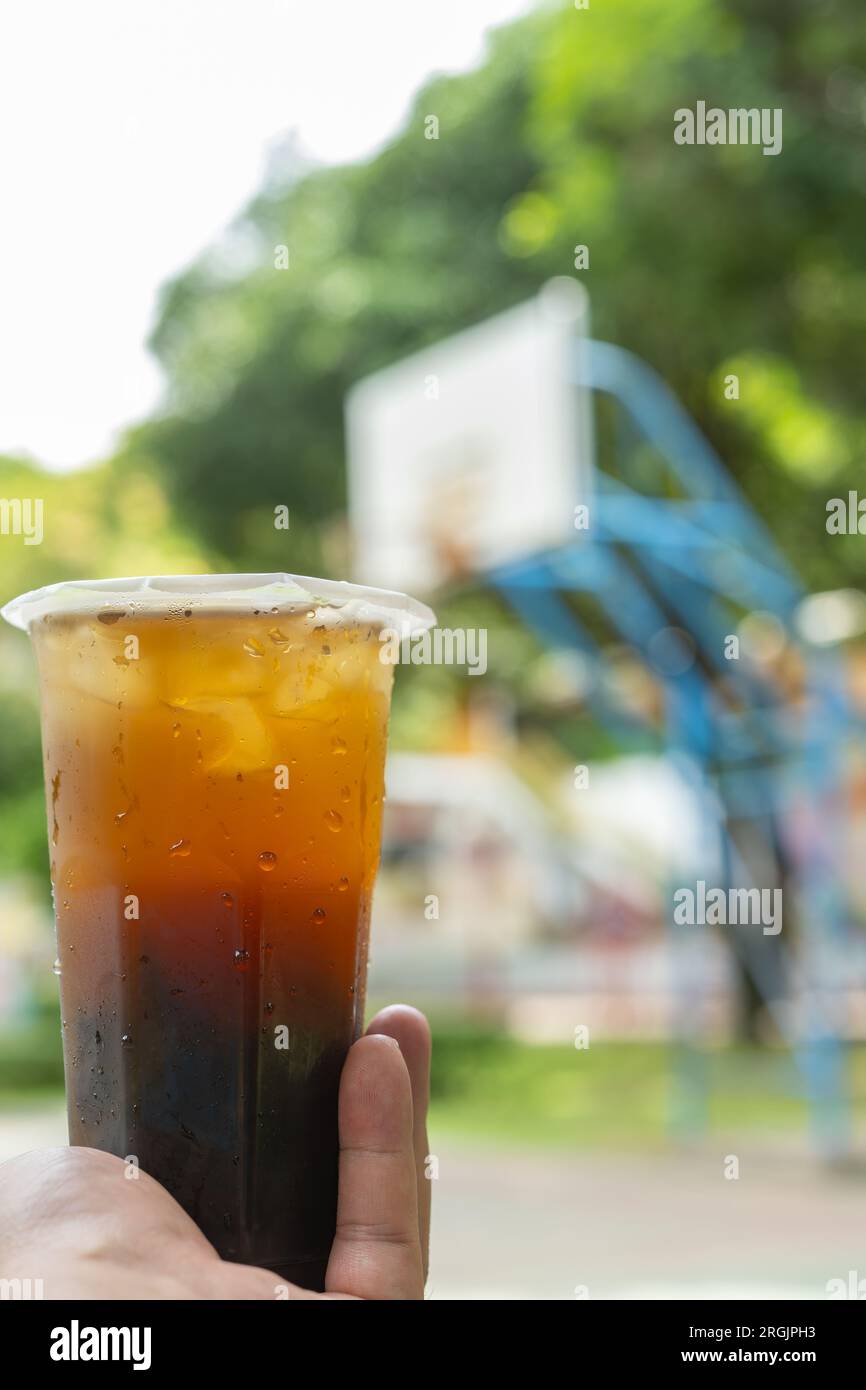 cup of iced tea with brown sugar in front of an outdoor basketball ...