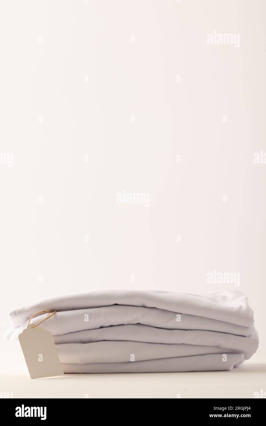 Stack of white t shirts with tag and copy space on white background ...