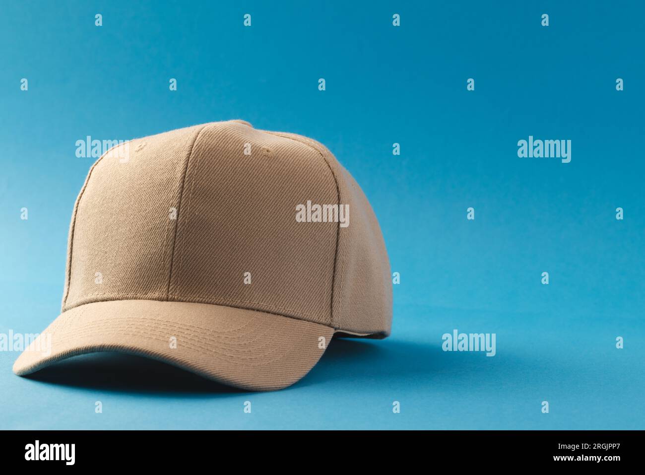 Cream baseball cap and copy space on blue background Stock Photo - Alamy