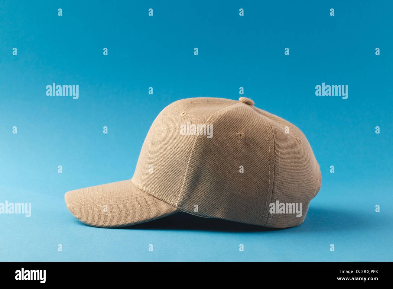 Cream baseball cap and copy space on blue background Stock Photo - Alamy